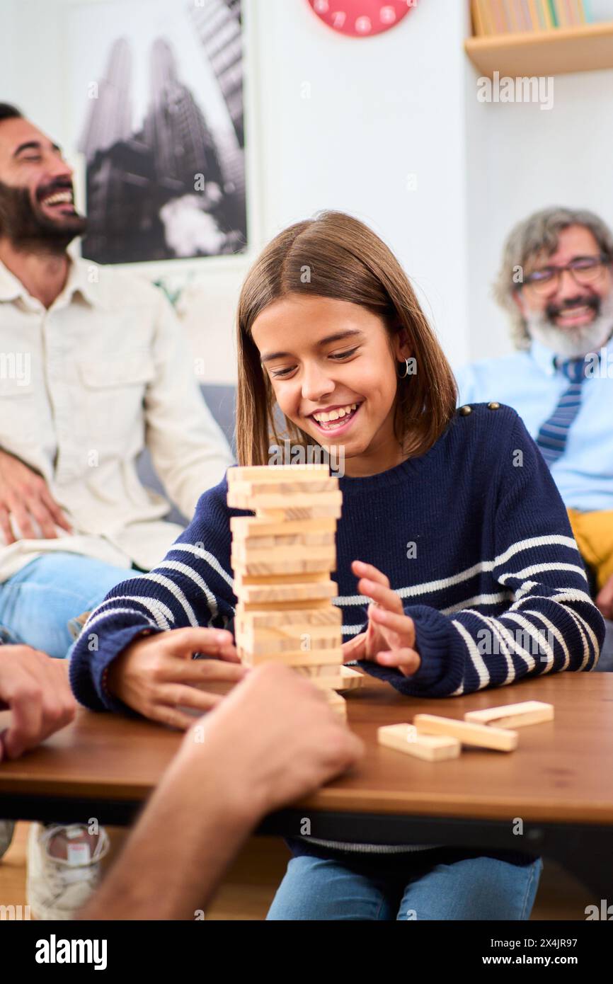 Happy diverse generation family gathered playing Jenga at home ...