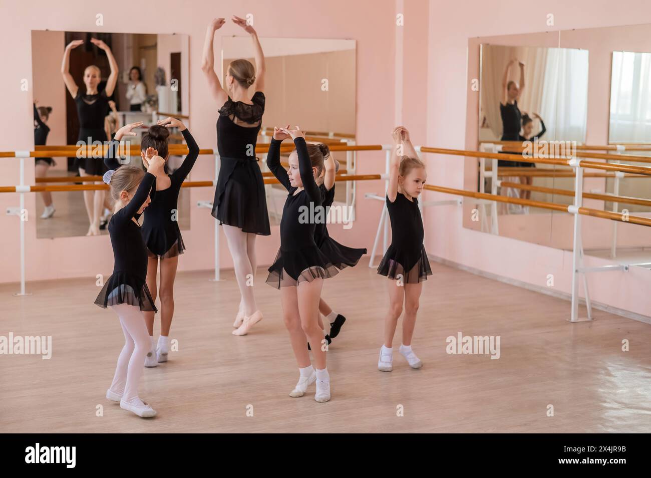 Children's ballet school. Caucasian woman teaching ballet to little ...