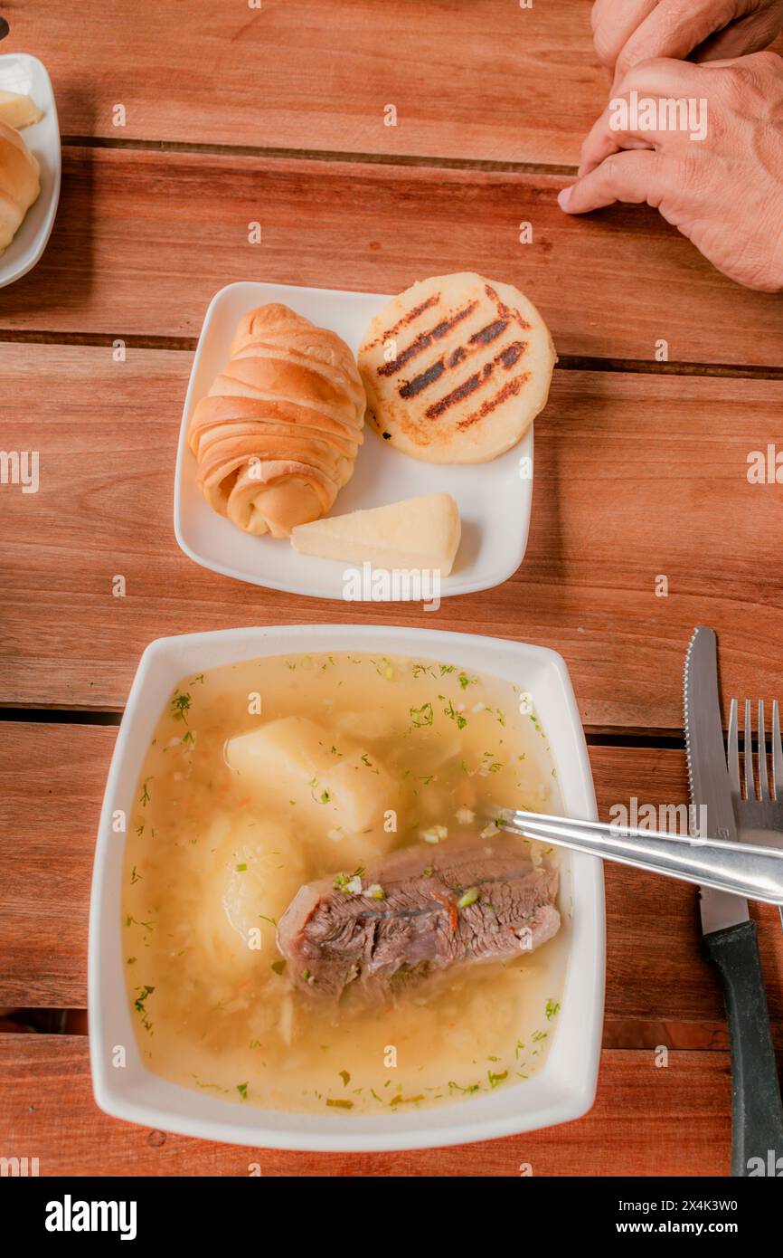 overhead view of a typical Colombian breakfast composed of meat broth ...