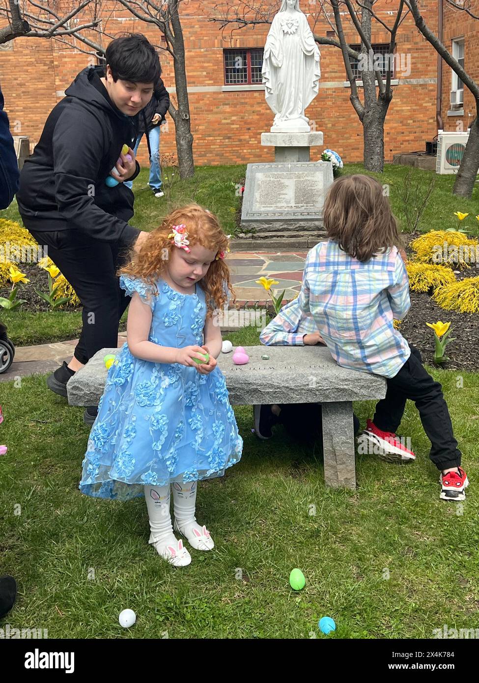 Children on an Easter Egg hunt after Catholic mass in the churchyard on ...