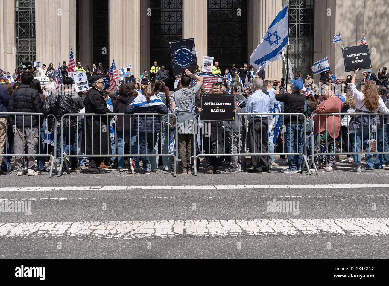 Israel supporters stand and wave flags and hold placards while ...