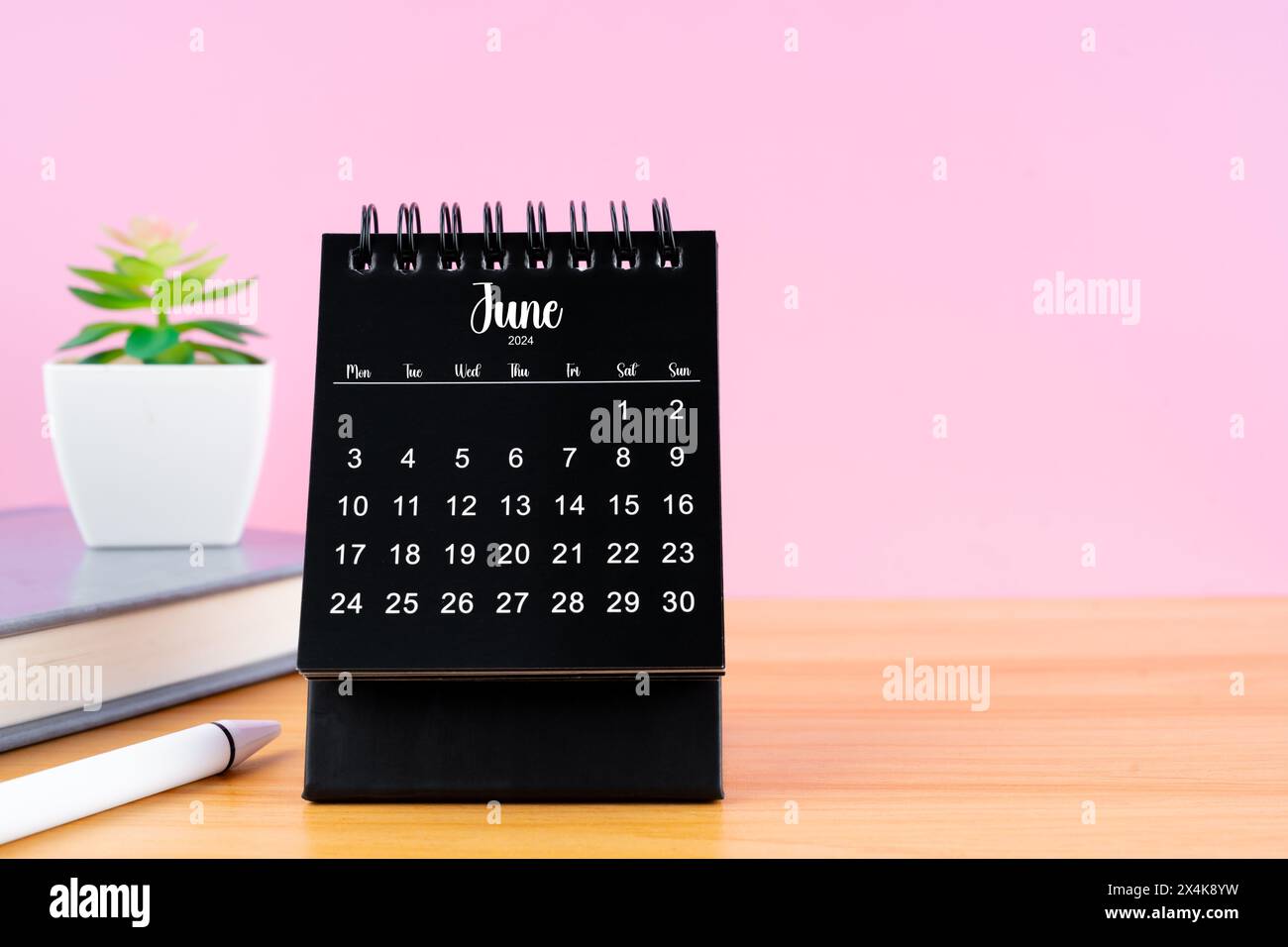 June Mini desk calendar for 2024 year on worktable with pink color ...