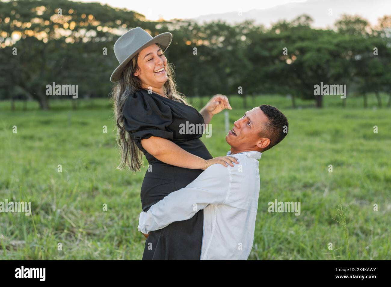 brown dark-haired latin man straining hard to lift his girlfriend while ...