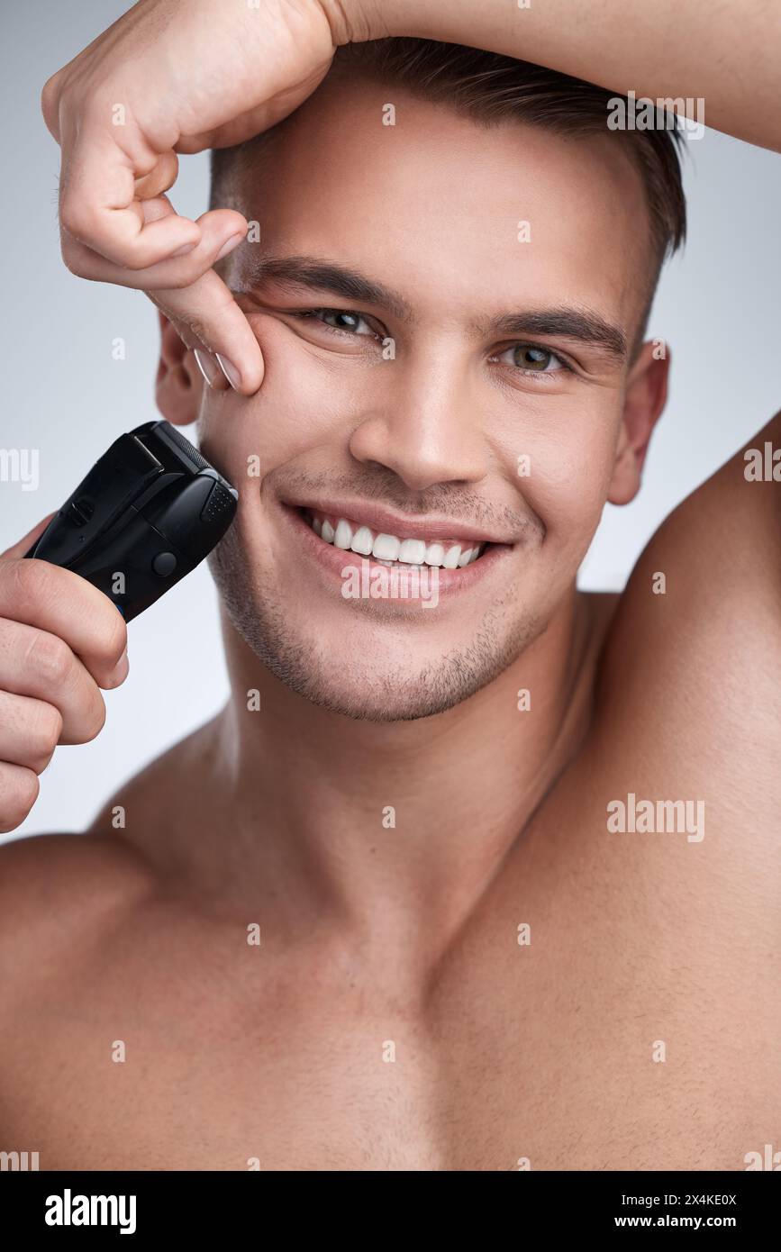 Portrait, man and studio with electric razor, skincare and hygiene for ...