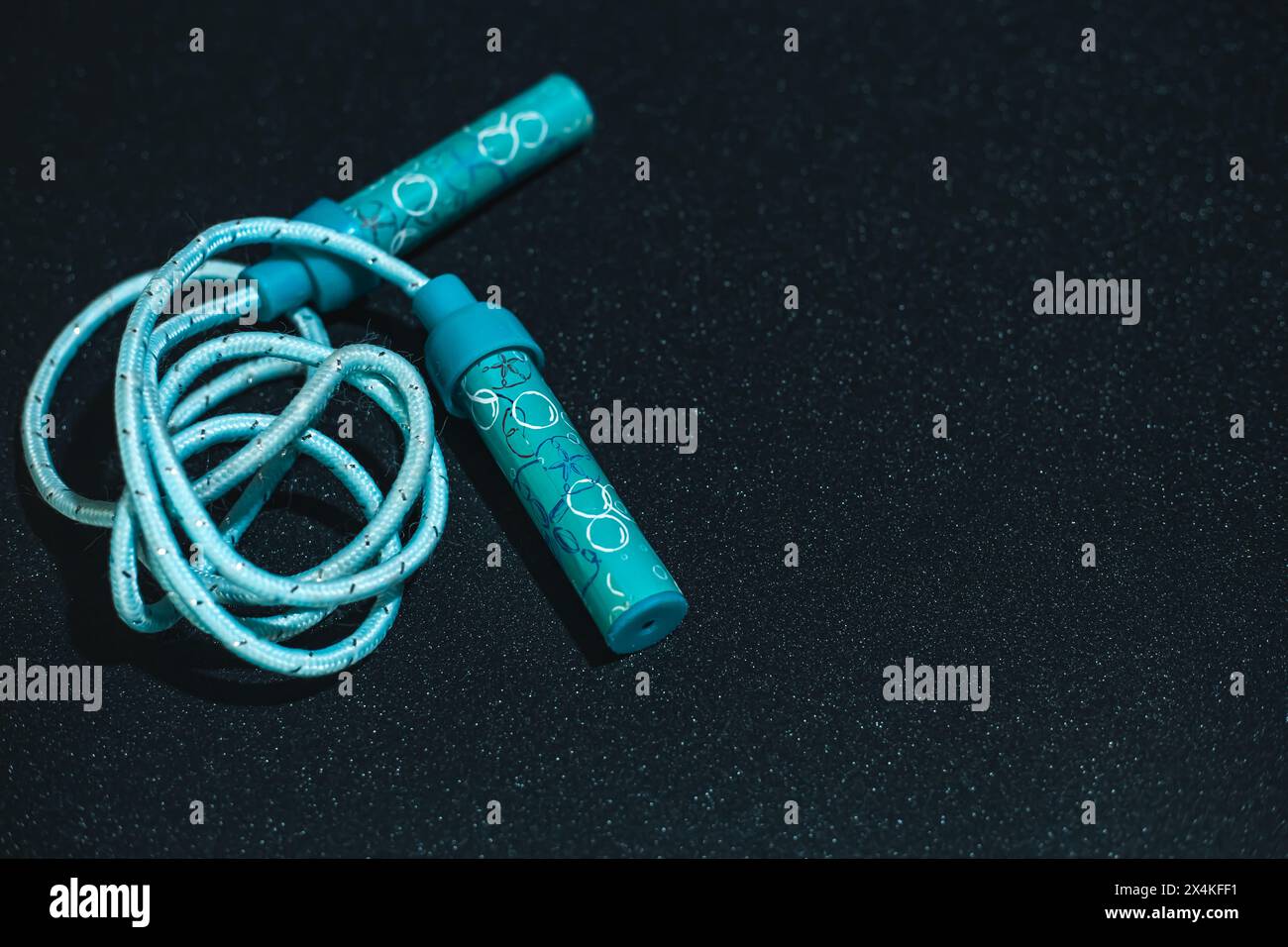 Sports Jumping rope on a black background. Blue children's jump rope on ...