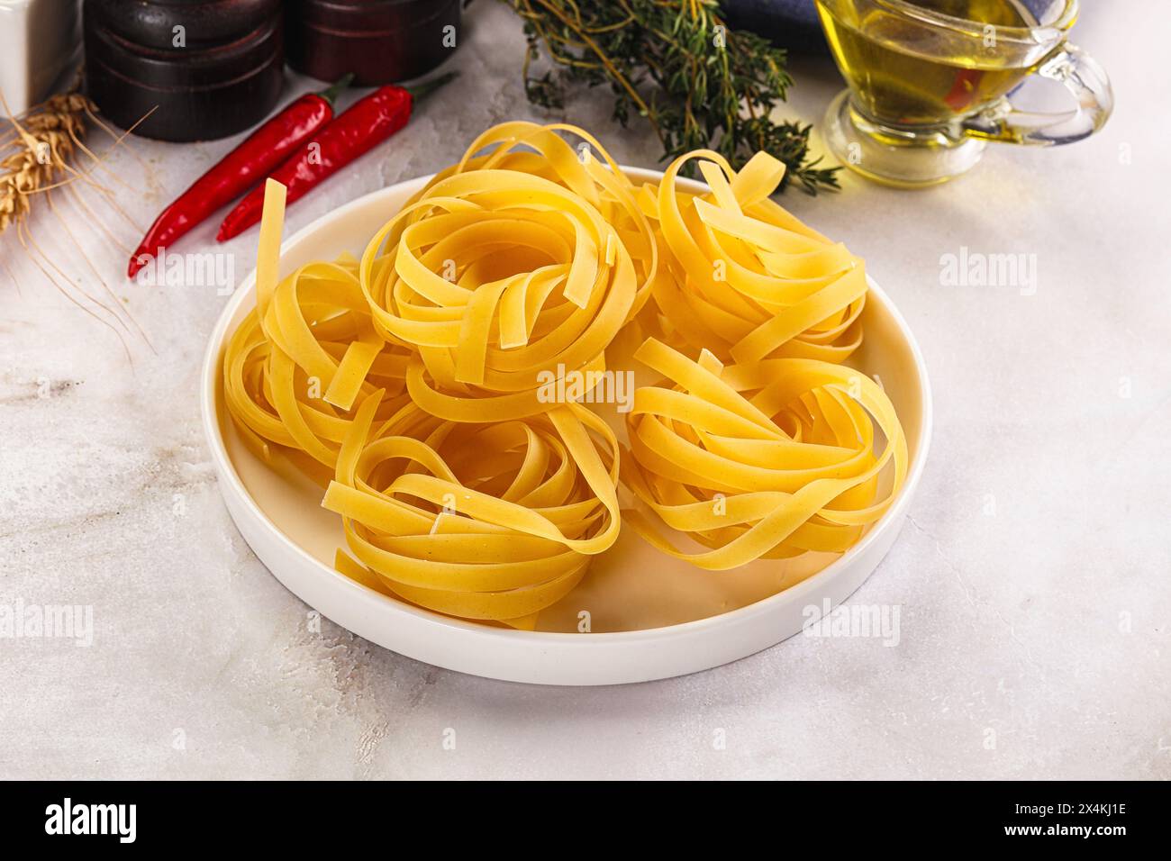 Raw dry Italian pasta - pappardelle for bowl Stock Photo - Alamy