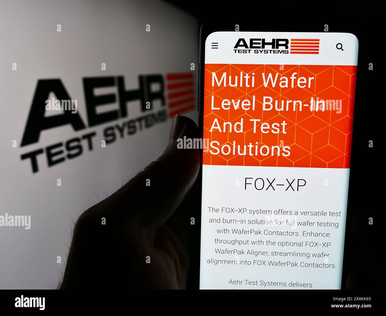 Person holding cellphone with webpage of US semiconductor testing ...