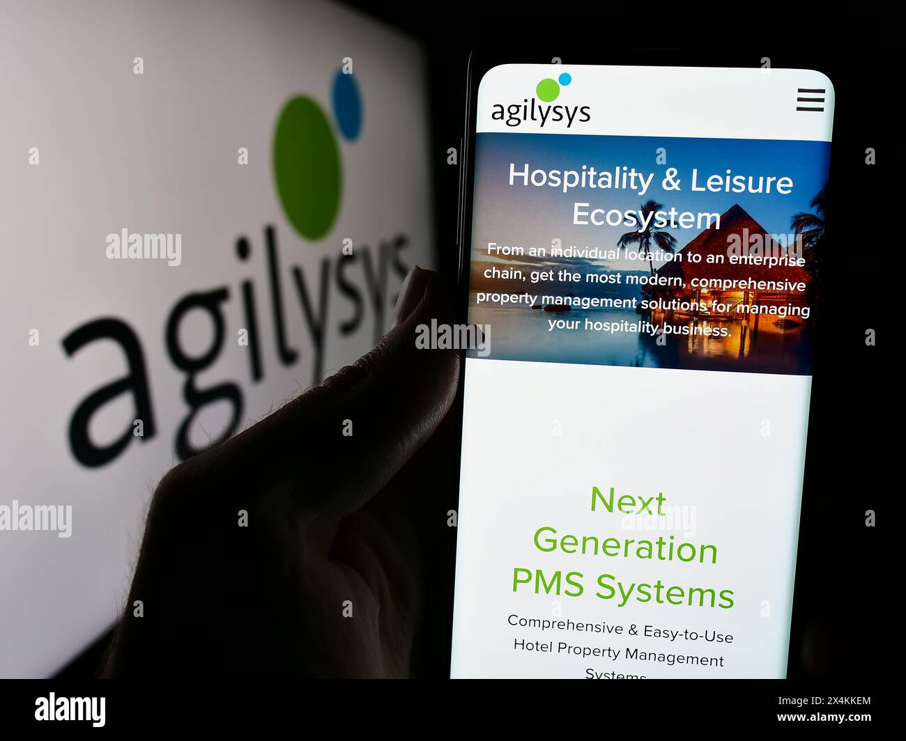 Person holding cellphone with webpage of US enterprise software company ...