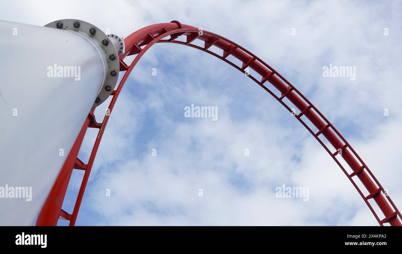 Red coloured roller coaster track of an extreme roller coaster, during ...