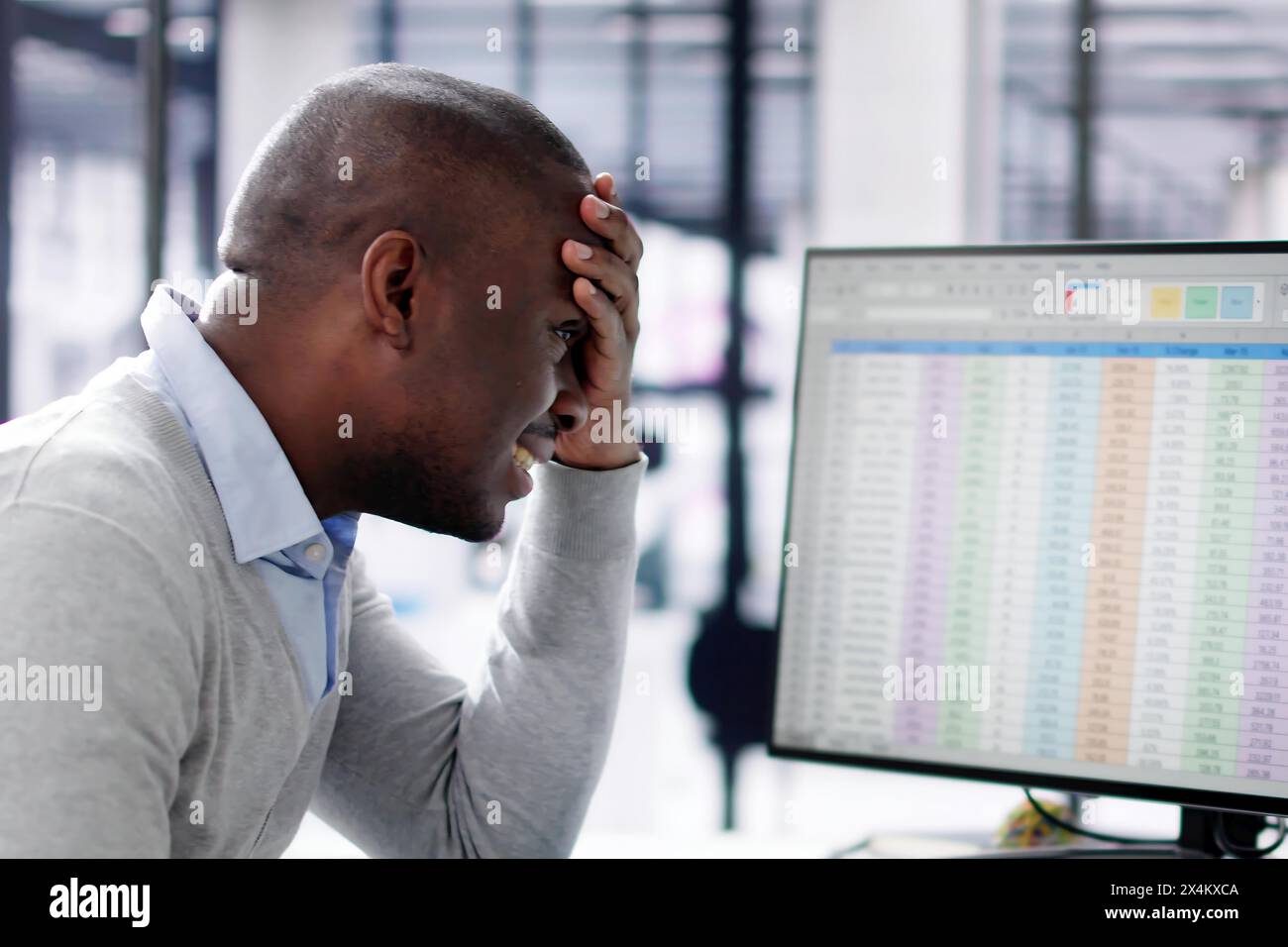 African man using spreadsheets looks unhappy analyzing data Stock Photo ...