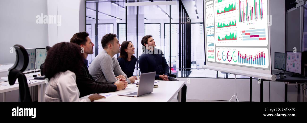 Business group meeting analyzing financial KPIs on computer dashboard ...