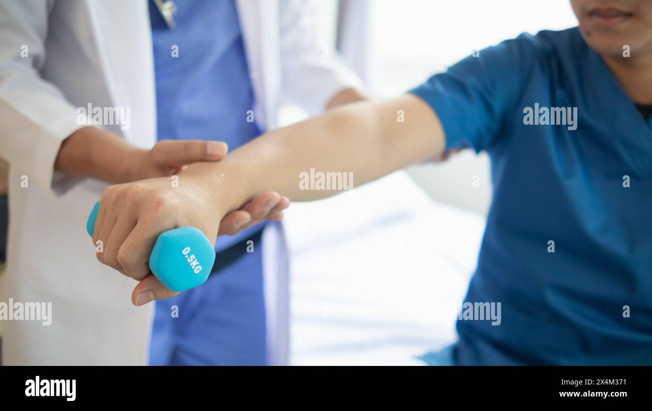 doctor is checking for muscle injuries and using dumbbells test injury ...