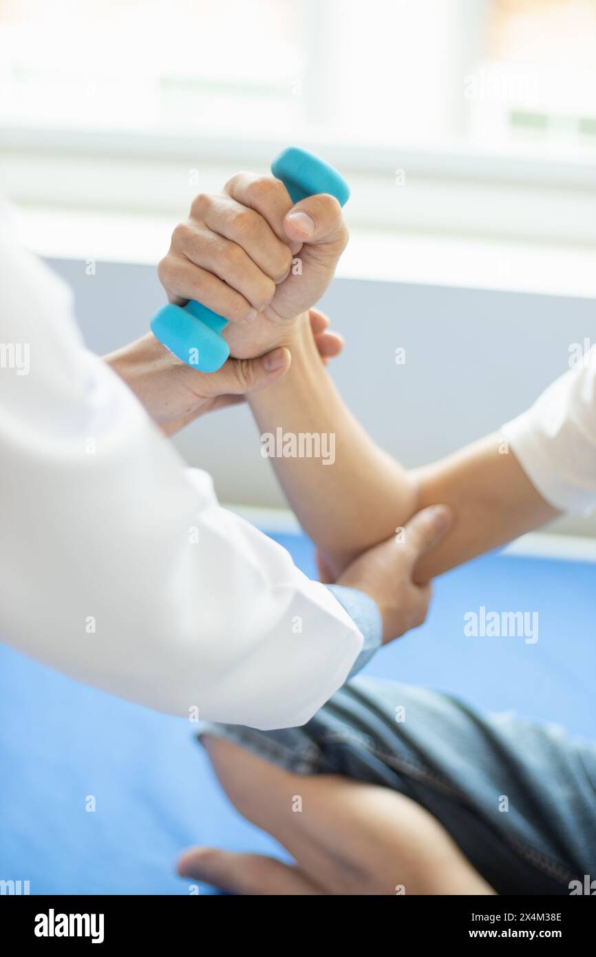 doctor is checking for muscle injuries and using dumbbells test injury ...