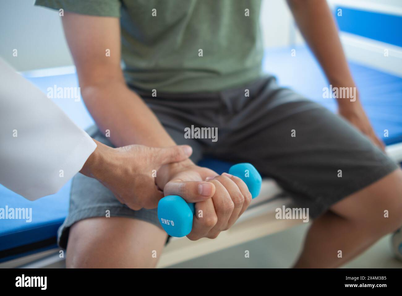 doctor is checking for muscle injuries and using dumbbells test injury ...
