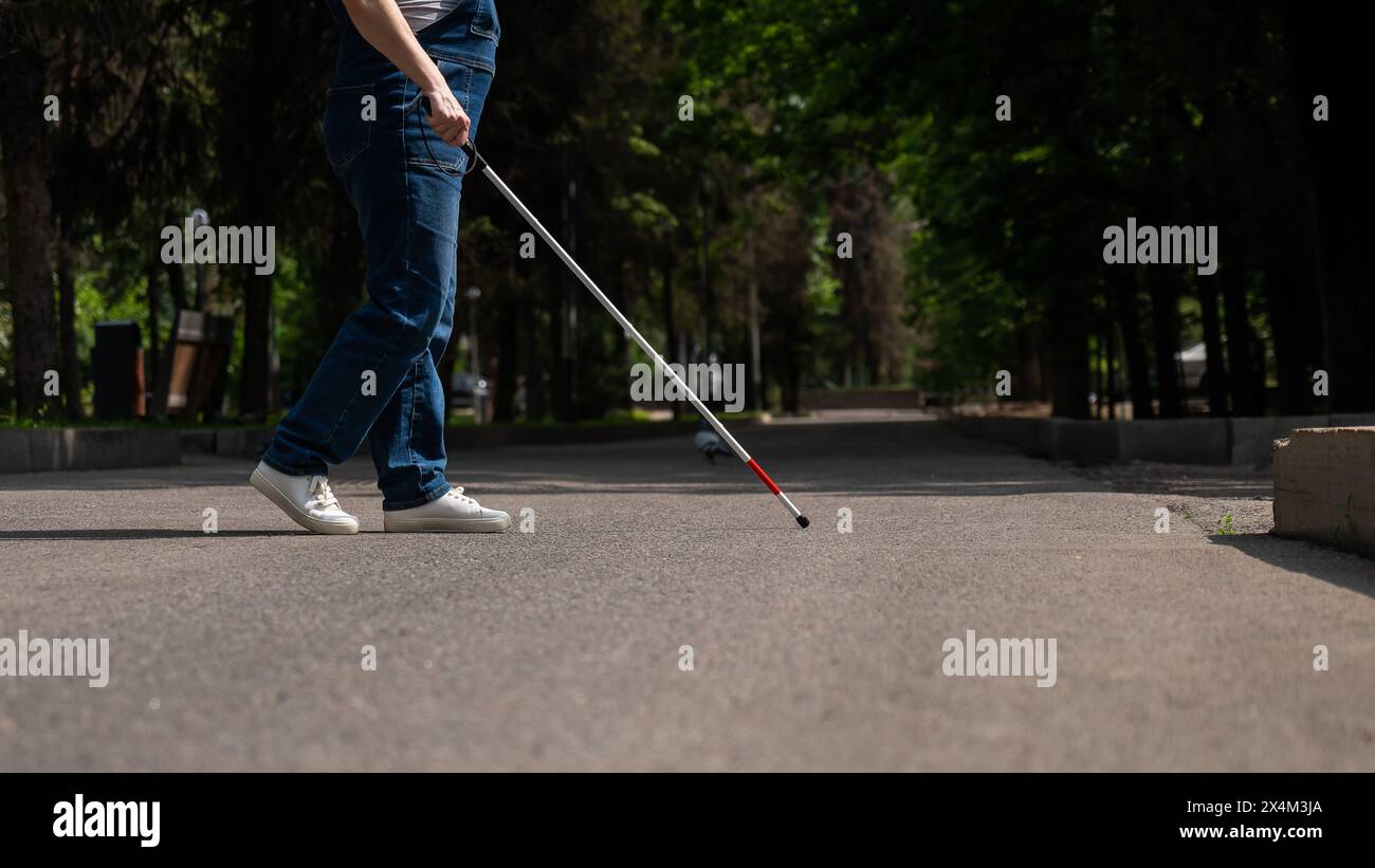 Blind woman crosses the street with the help of a tactile cane Stock ...