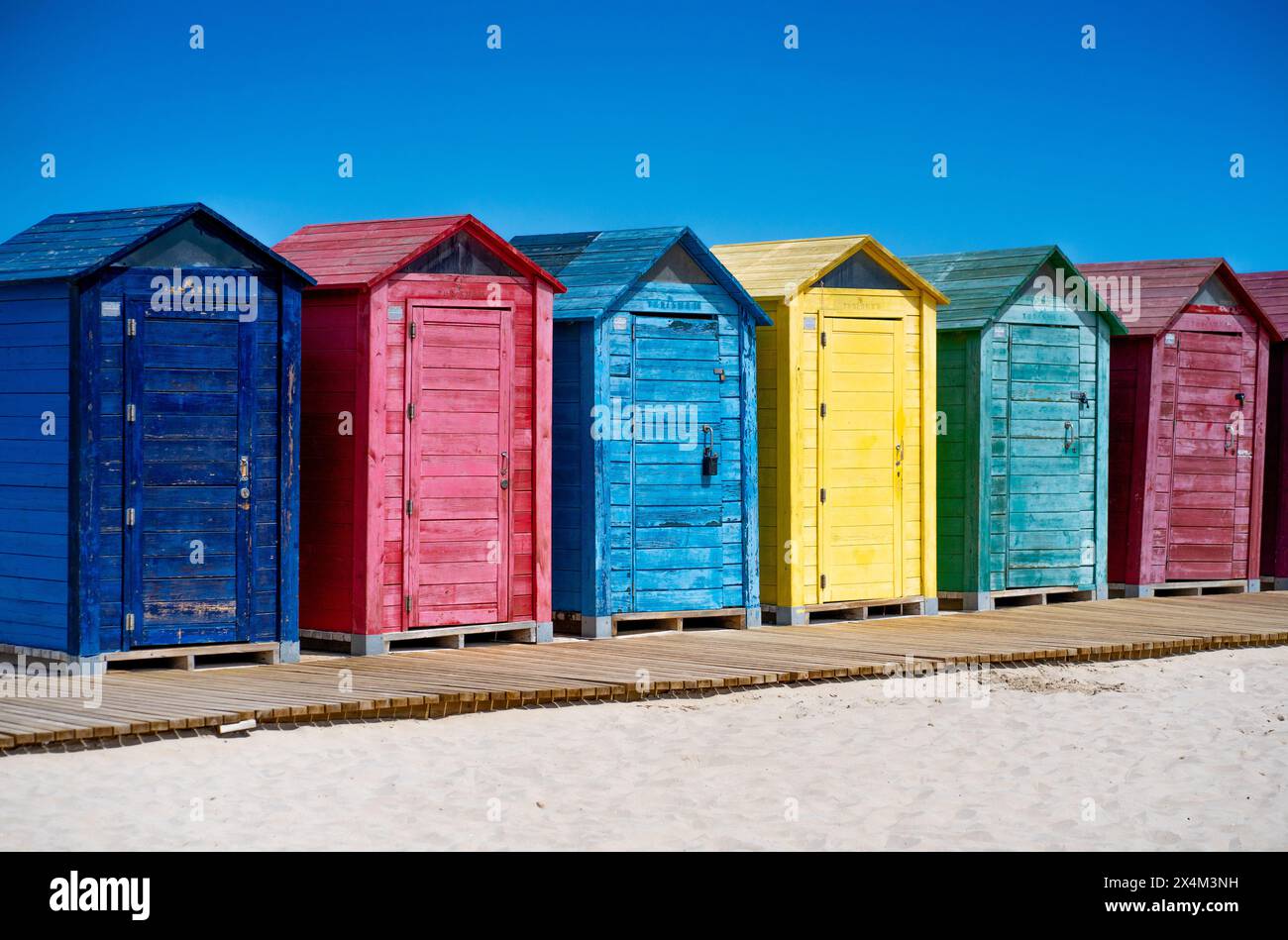 Colorful beach huts built of wood arranged in a row on the sand Stock ...