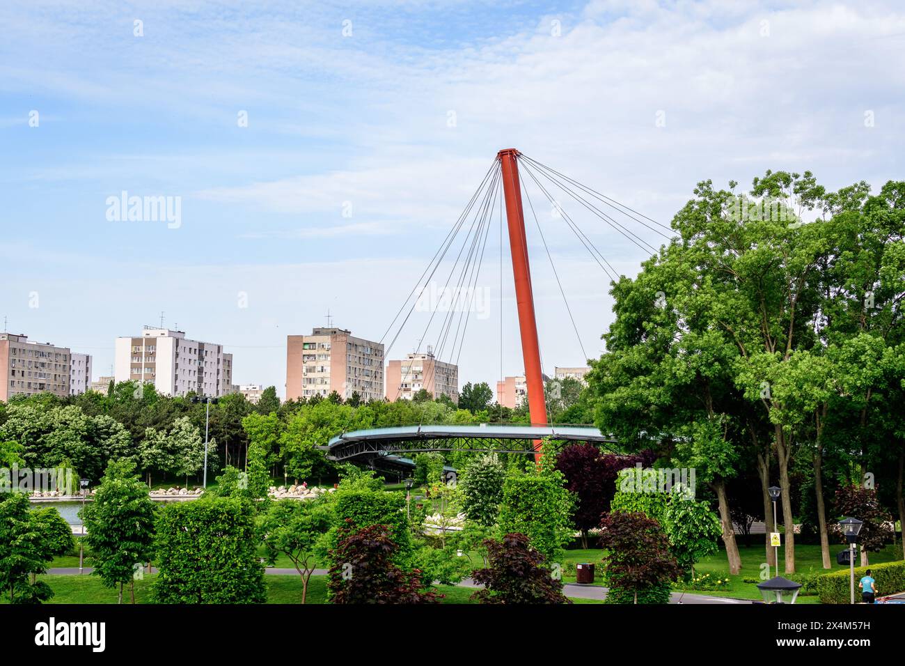 Landscape with the modern red metallic bridge and vivid green grass and ...