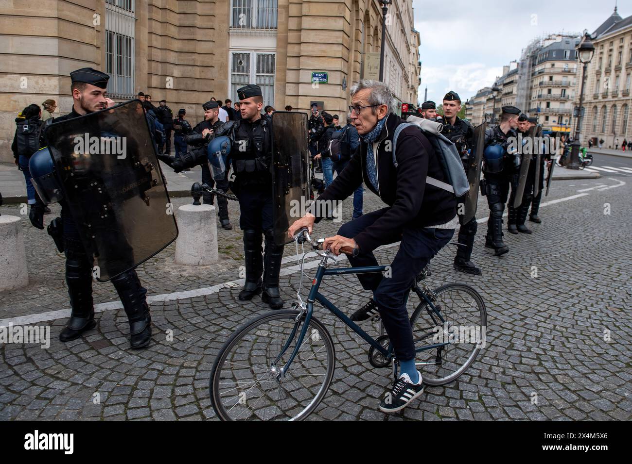 A man rides his bike past a line of French Riot police near a Pro ...