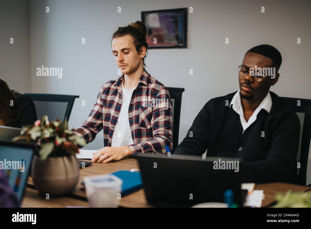 Focused team members engage in a productive business meeting in a modern office setting Stock ...