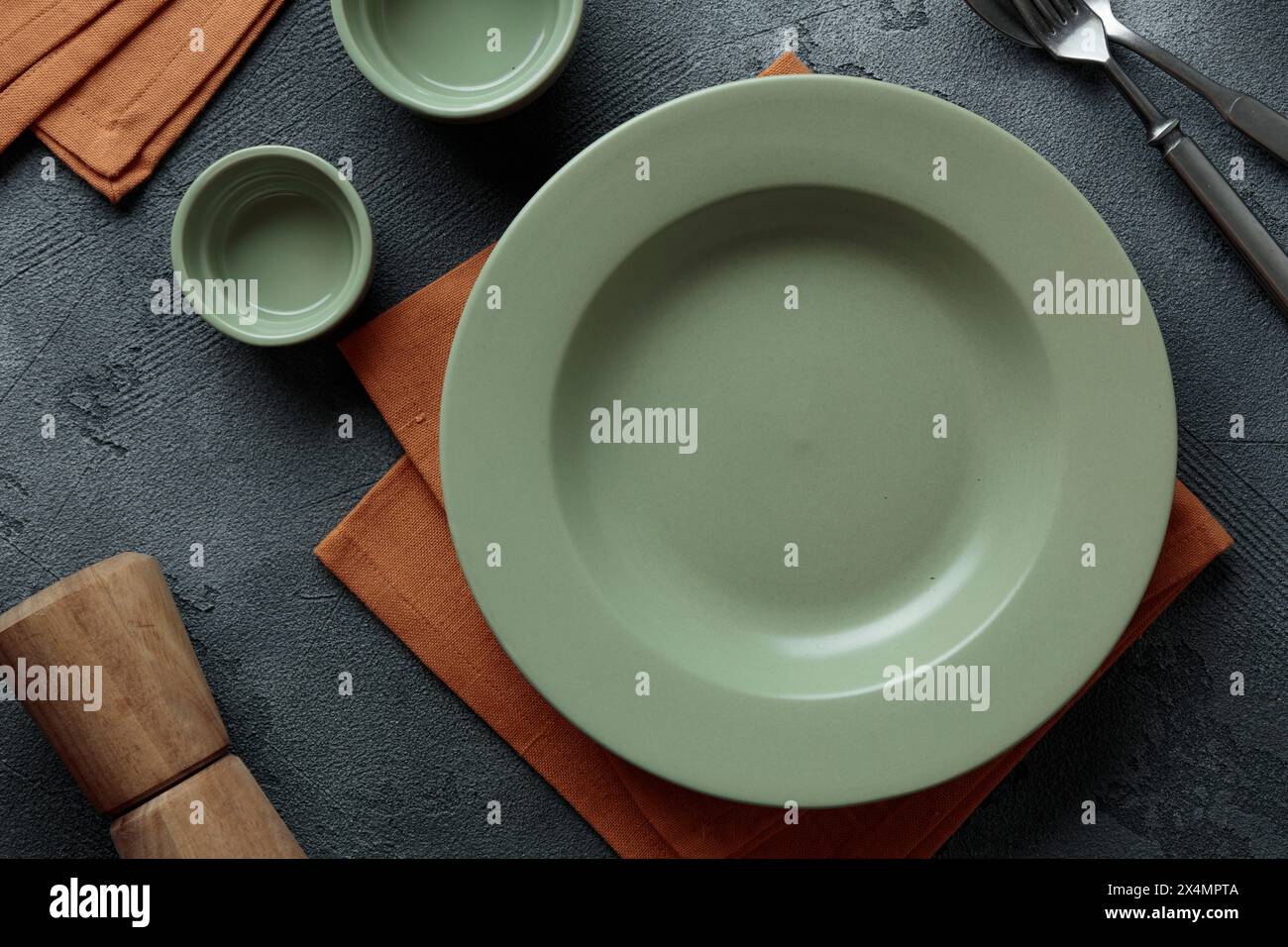 Green empty plate, cutlery and napkin on stone table top view. Table ...