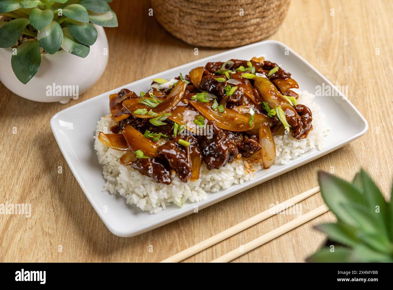Savory mongolian beef dish on rice with chopsticks Stock Photo - Alamy
