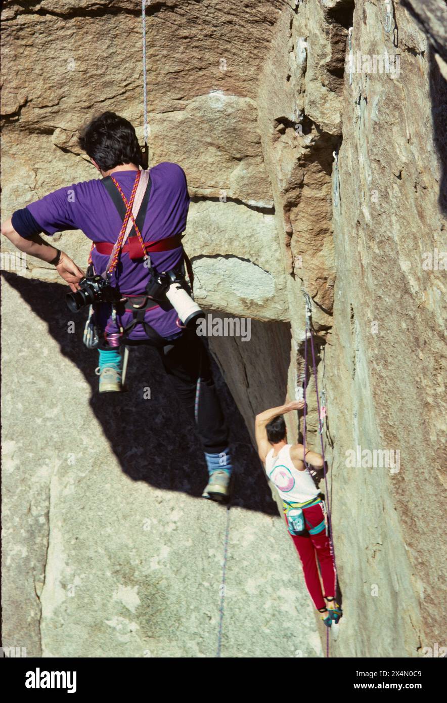 Photographer Tony Wright suspended on a rope photographing climber ...
