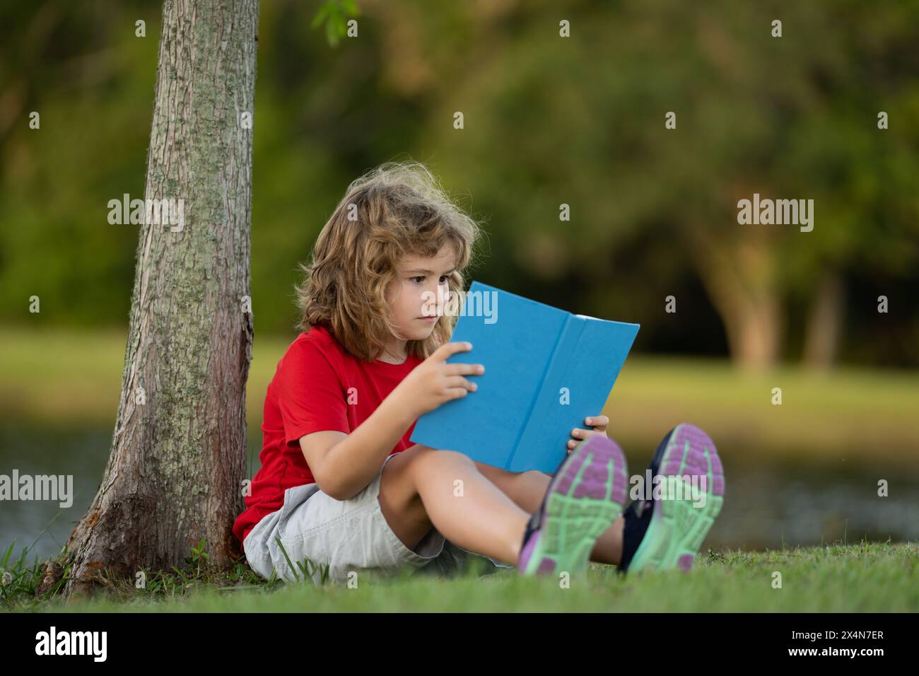 Child read a book. Elementary outdoor school. Early education for ...