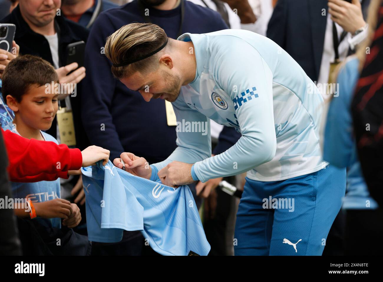 Manchester City's Jack Grealish signs an autograph for a fan before the ...