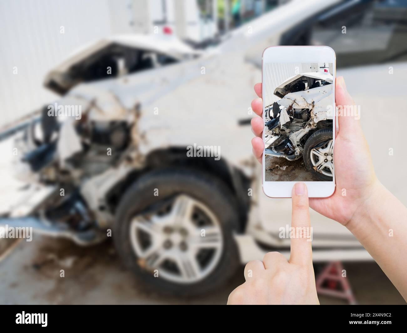Female using mobile smart phone taking photo of the car crash accident ...