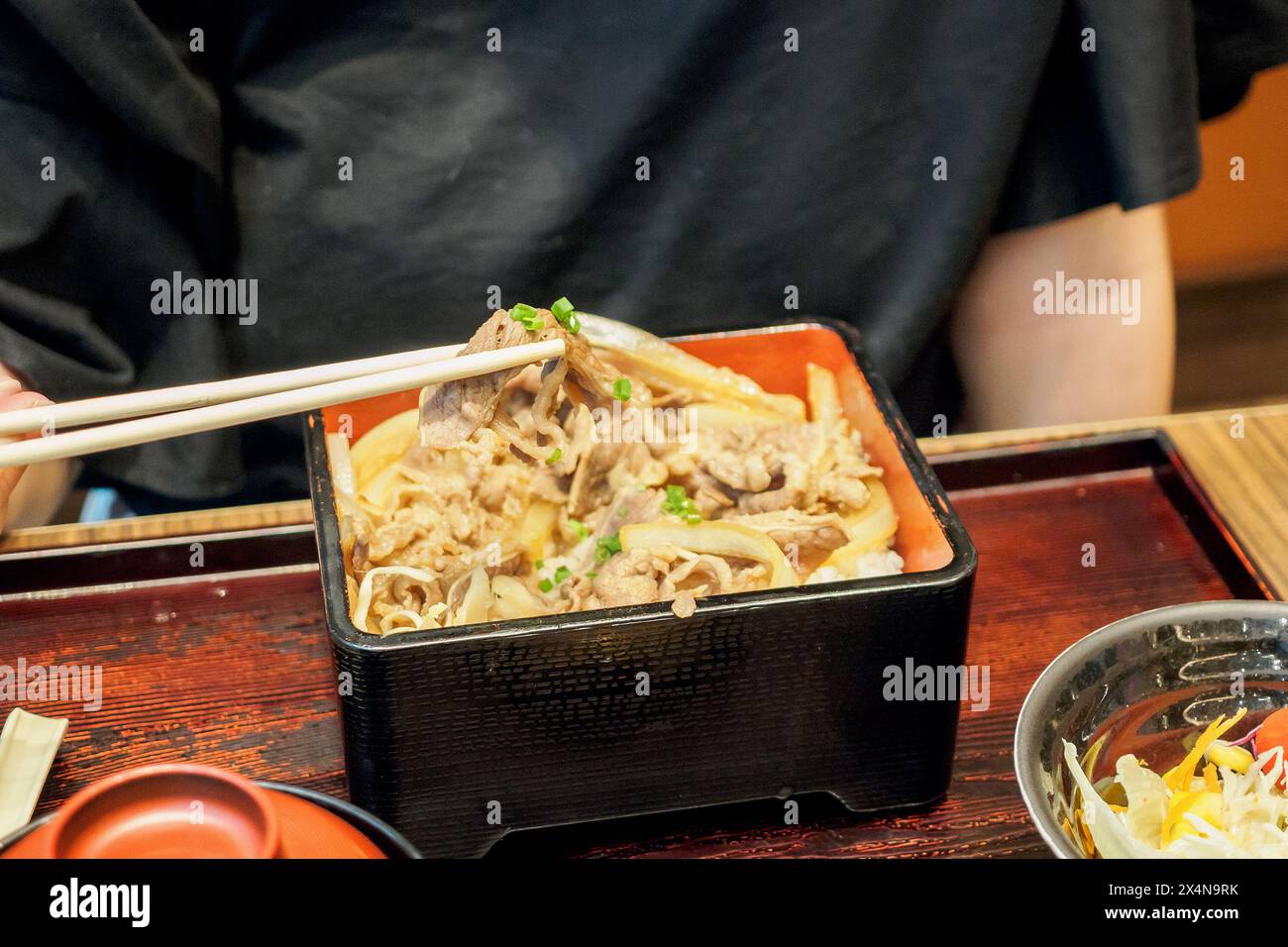 Asian Woman ready to eat Japanese food grilled beef meal with rice, Gyu Donburi in bento box ...