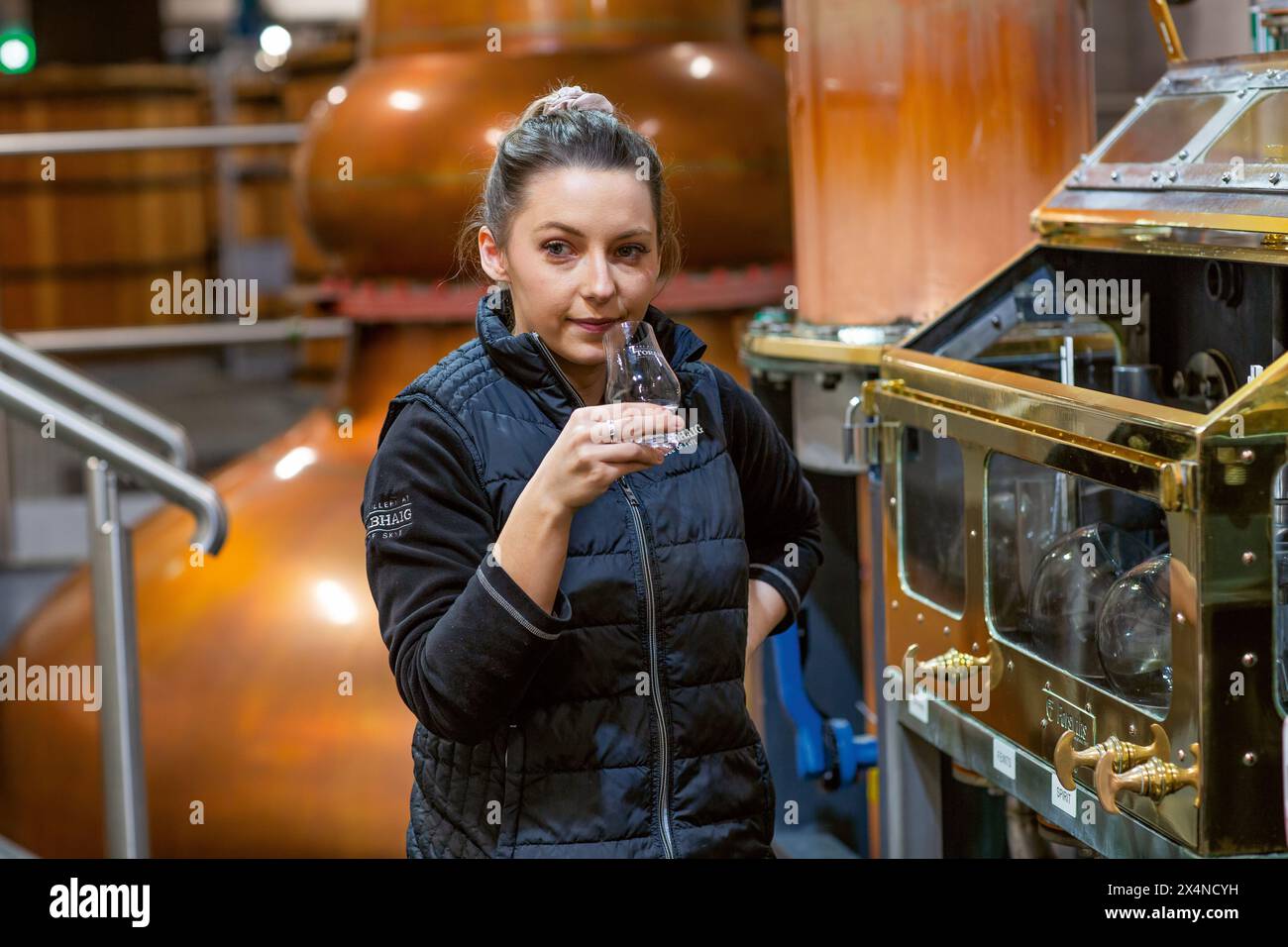 Female whiskymaker, nosing whisky glass sample at the Torabhaig ...
