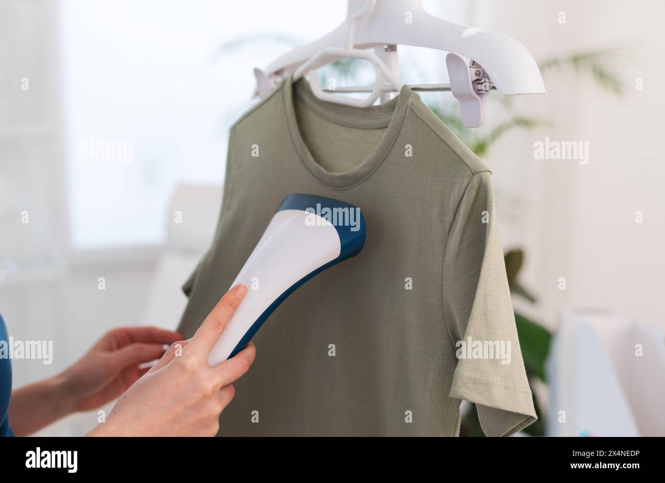 Using steaming iron to ironing t-shirt in home. Doing stream vapor iron ...