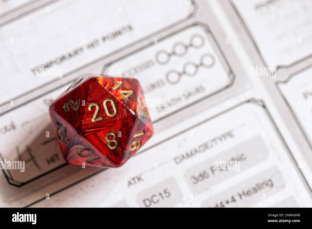 Sharp focus on a red D20 die resting on a detailed role-playing game ...