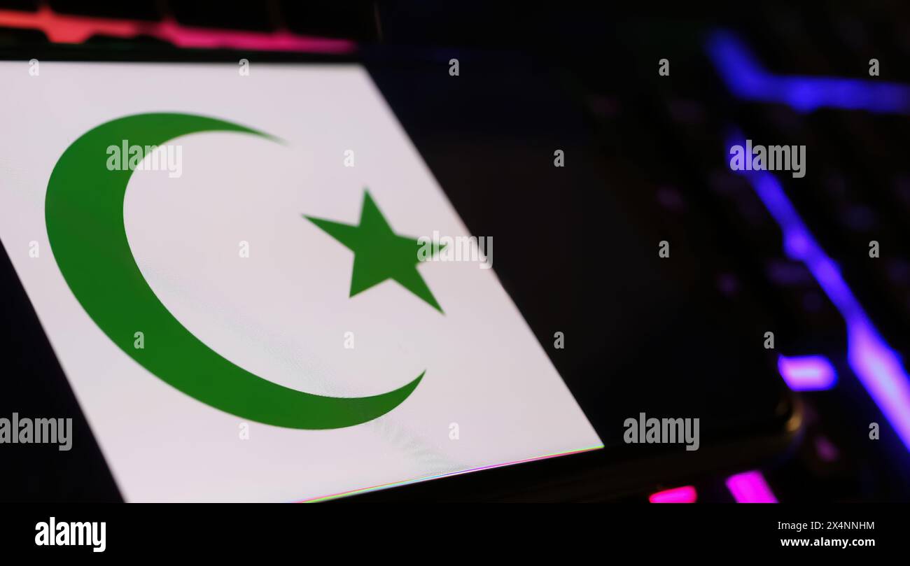Crescent moon and star islam symbol on smartphone screen with computer ...