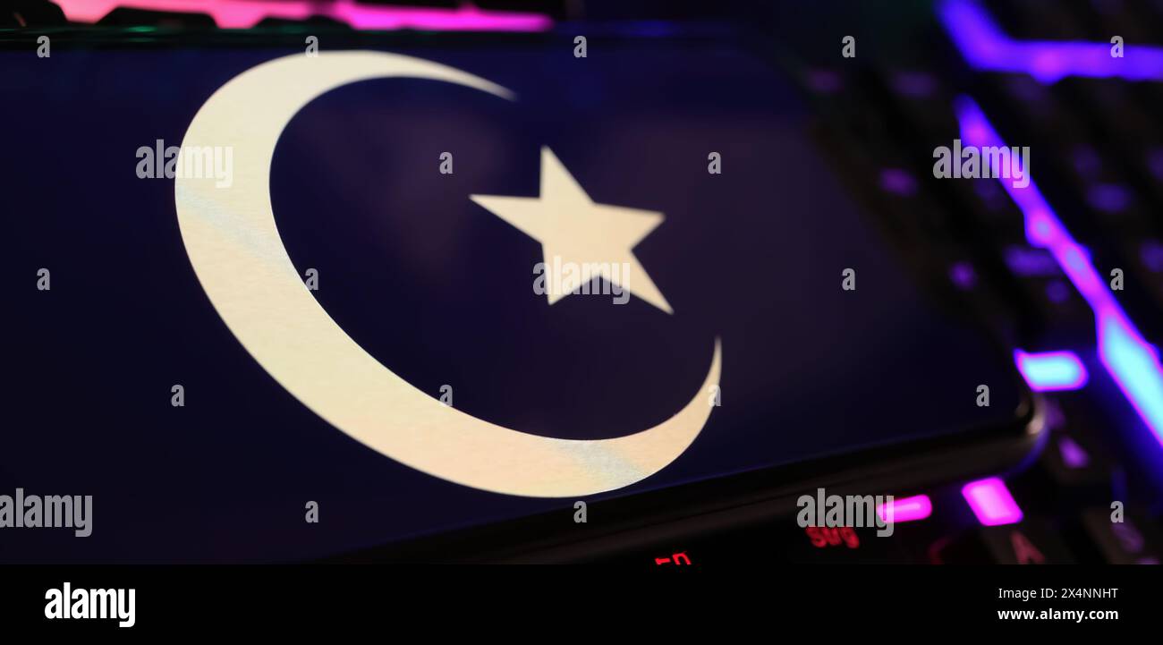 Crescent moon and star islam symbol on smartphone screen with computer ...
