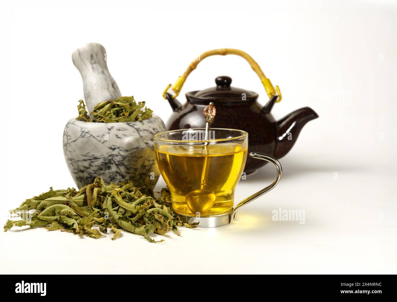 Lemon verbena infusion in a glass cup with a marble mortar and pestle ...