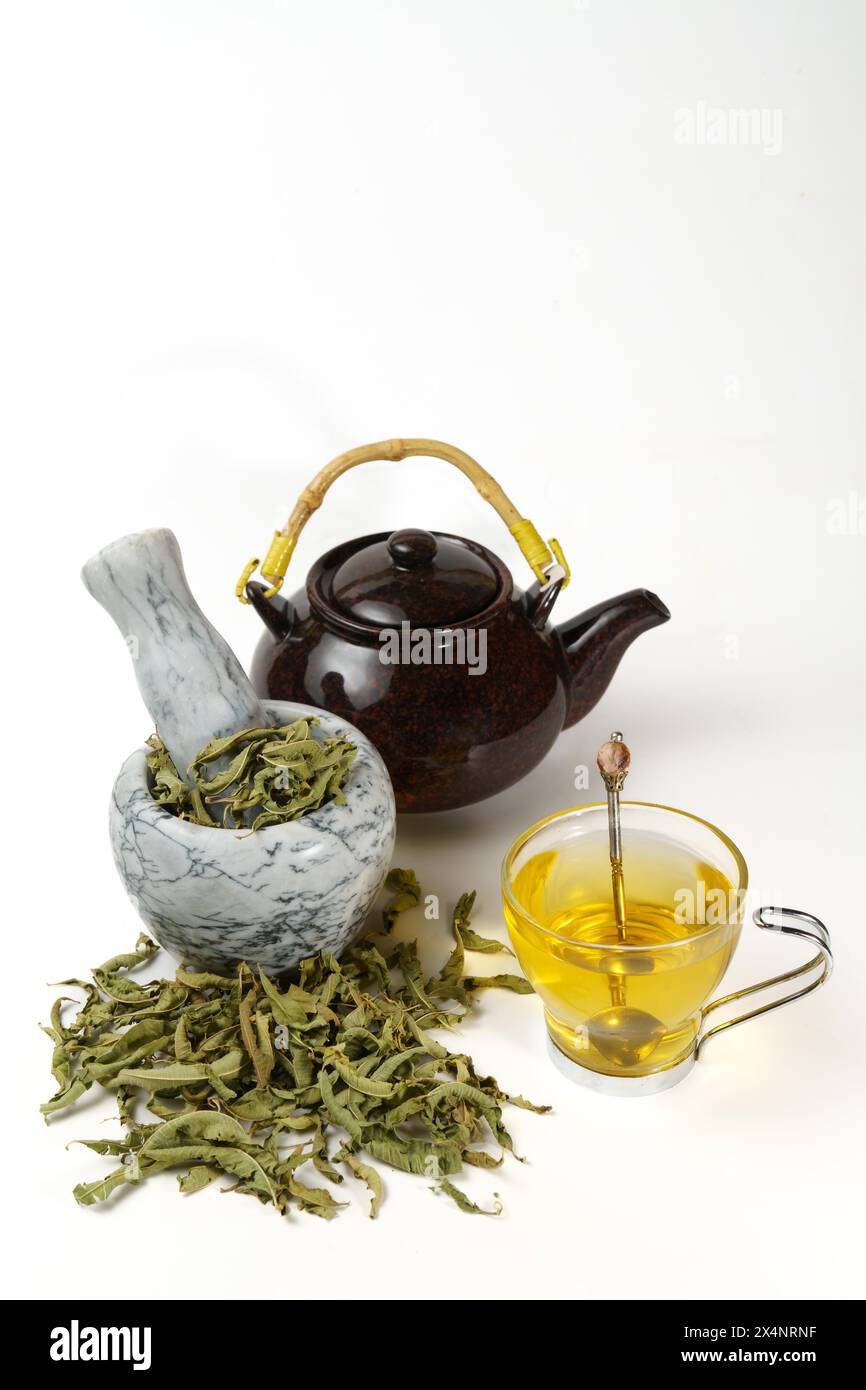 Lemon verbena infusion in a glass cup with a marble mortar and pestle ...