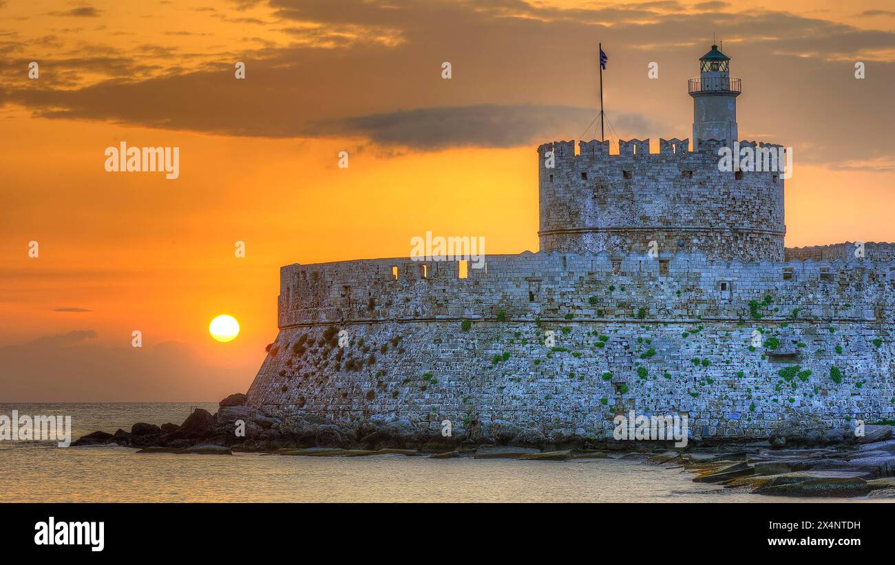 Silhouette of an old fortress and a lighthouse against the sunrise ...