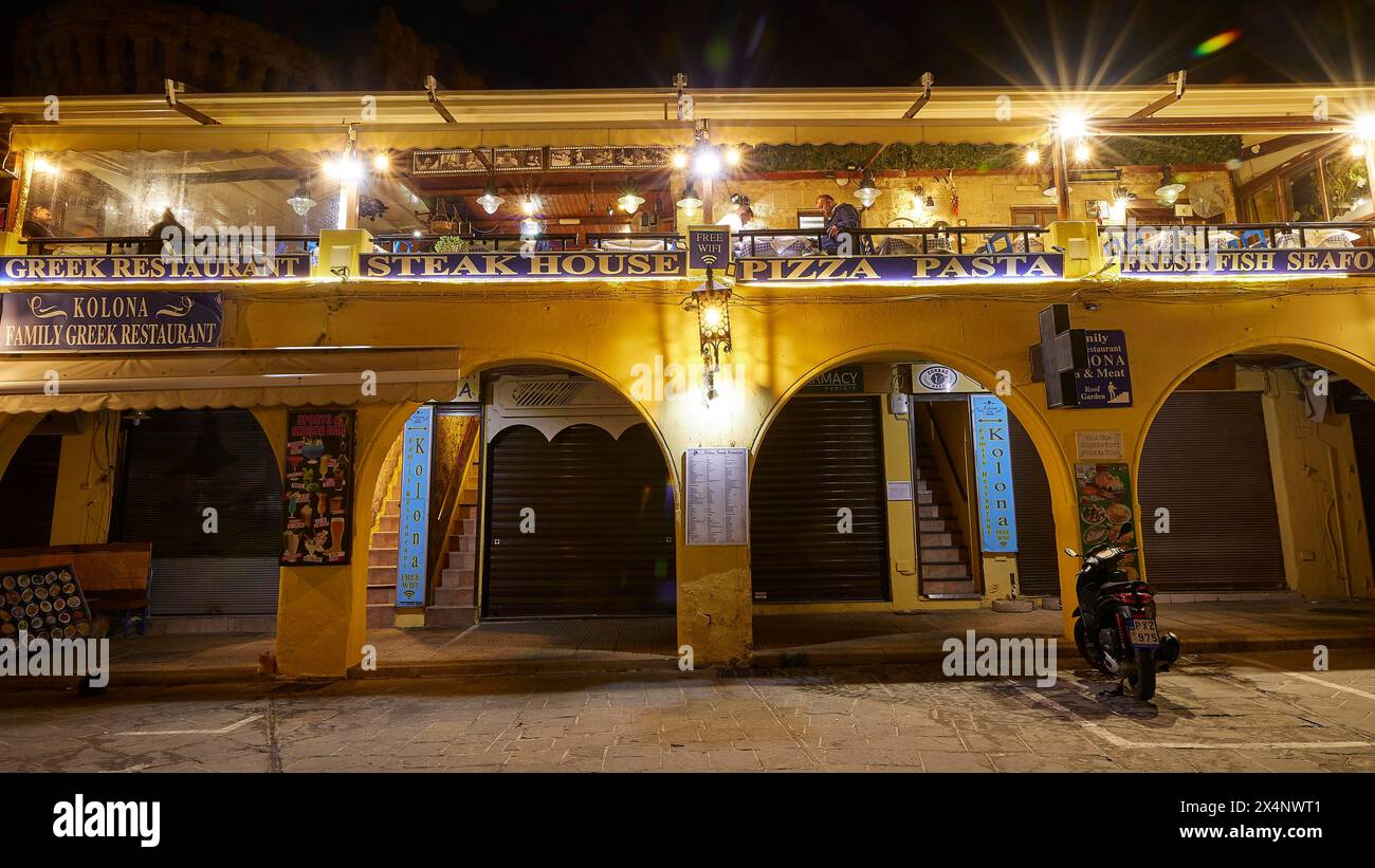 The facade of a restaurant at night, round arches, night shot, Rhodes ...