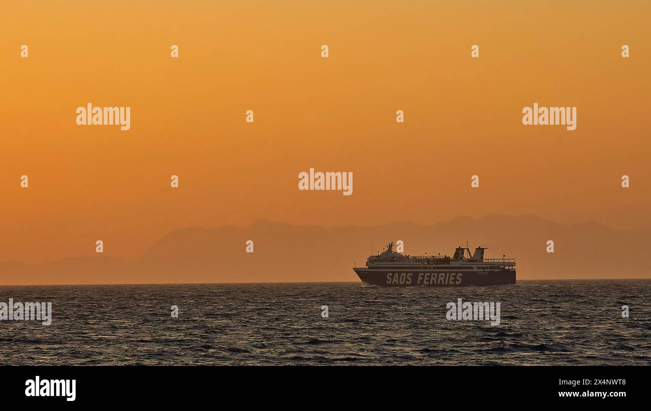 A ferry sails on the sea under a golden sunset sky, dusk, sunset ...