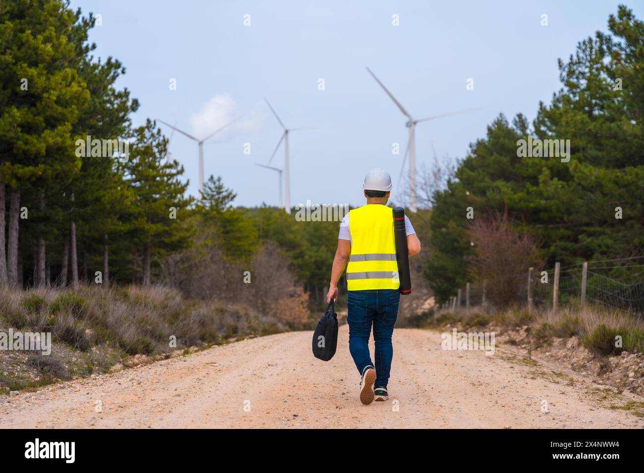 Rear view of a mature caucasian male worker walking along a path in a ...