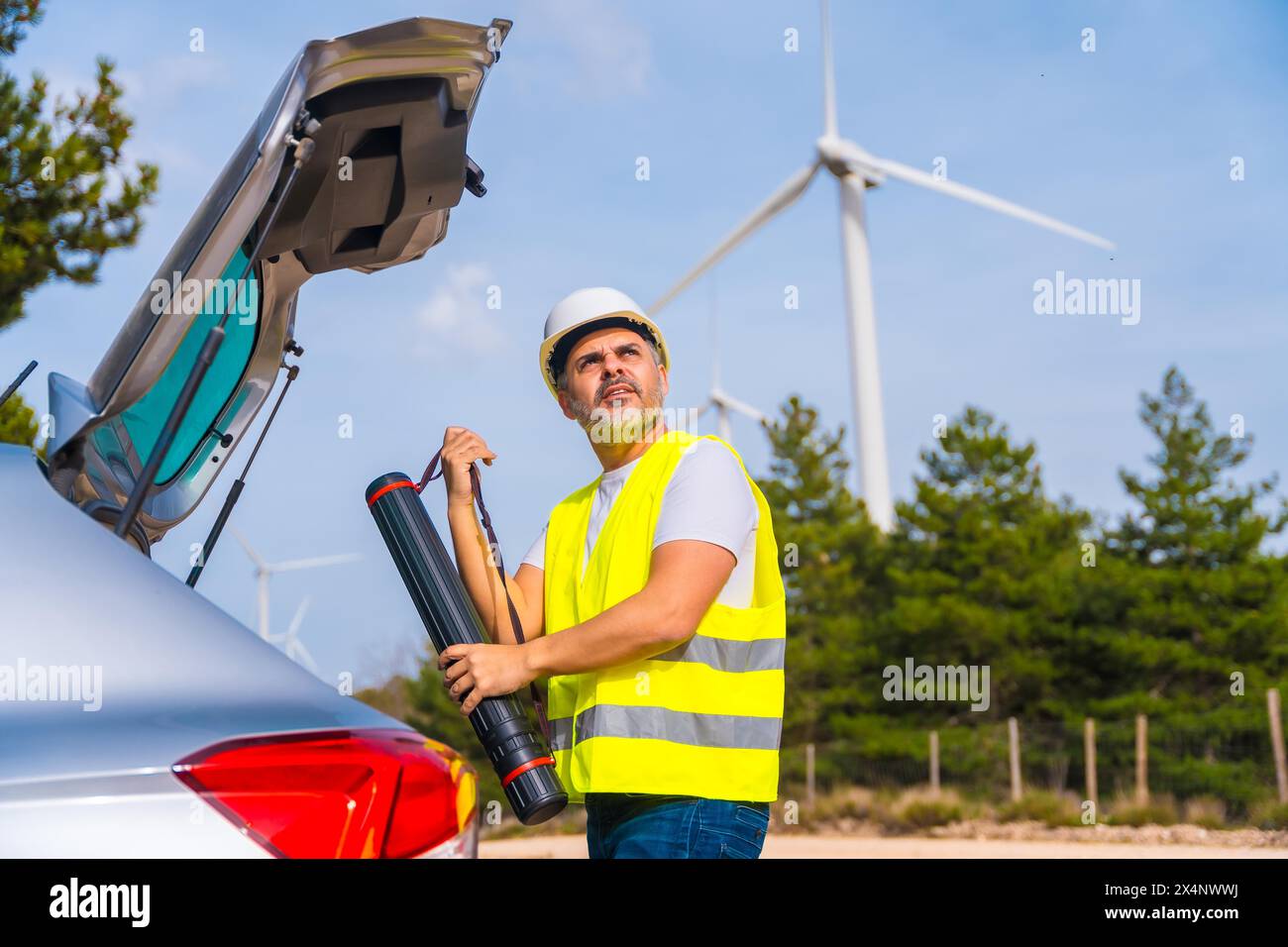 Profile photo of a male mature engineer carrying a drawing tube in a ...