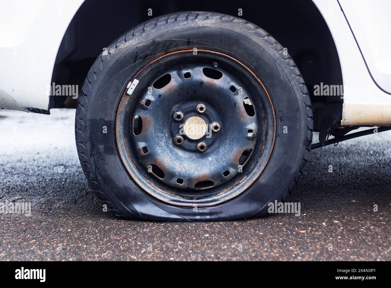 A car with a flat automotive tire on the side of the road, showing its ...