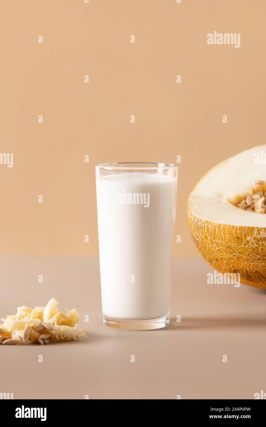 Alternative melon seeds milk and seeds on beige background. Close up ...