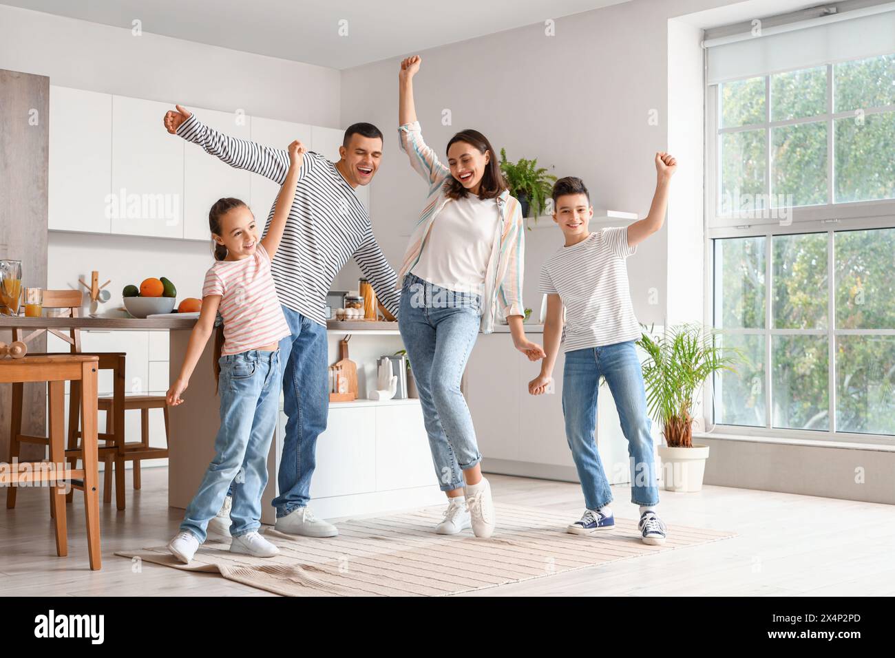 Happy family dancing in kitchen Stock Photo - Alamy