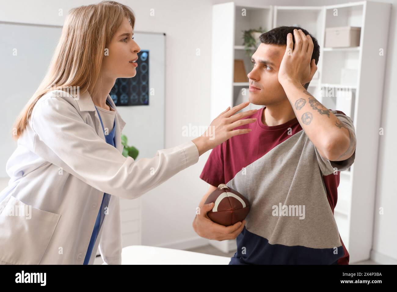 Female doctor examining rugby player with brain concussion in clinic ...