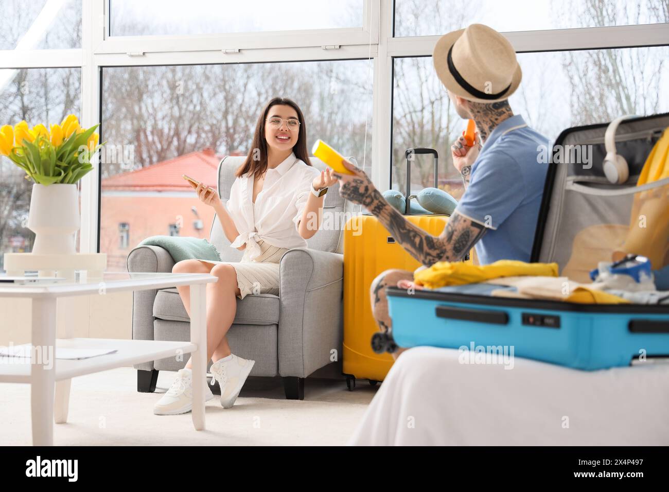 Female tourist with mobile phone and her husband in hotel room Stock ...