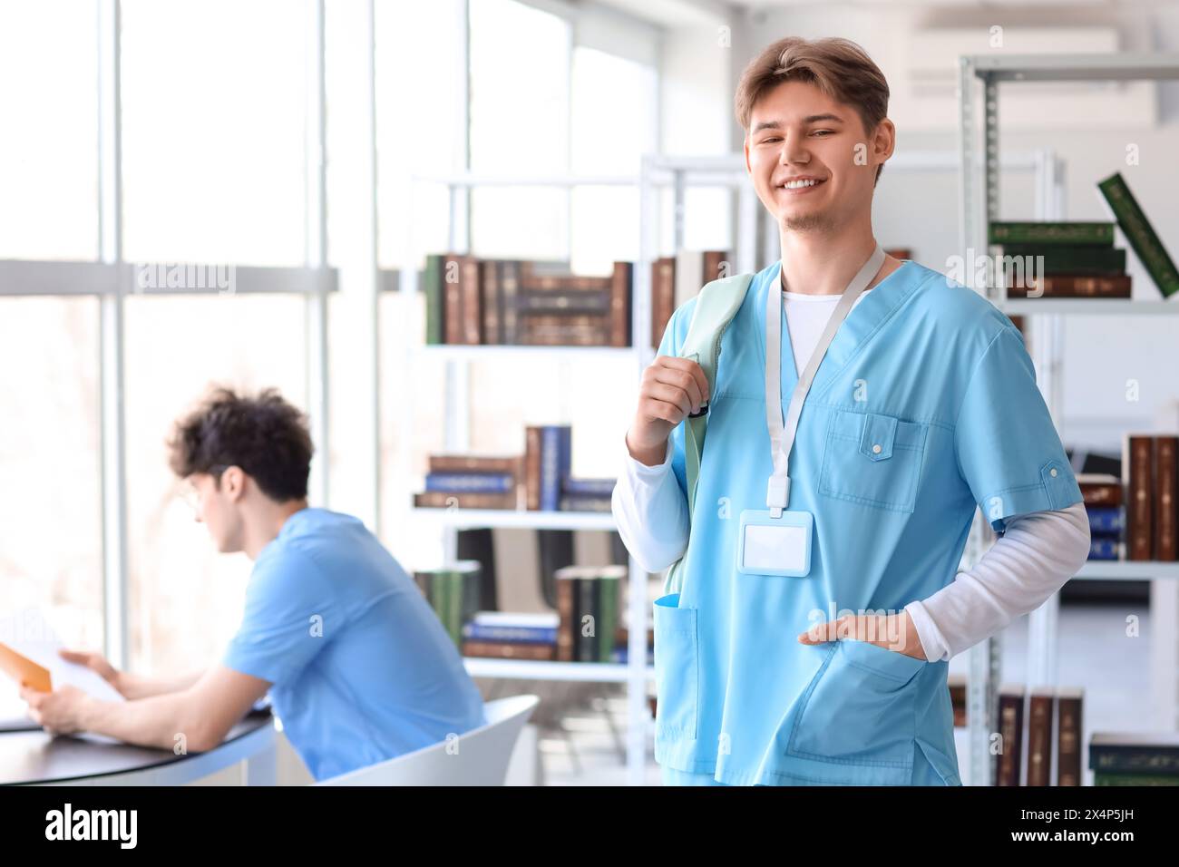 Male medical intern with backpack in library Stock Photo - Alamy