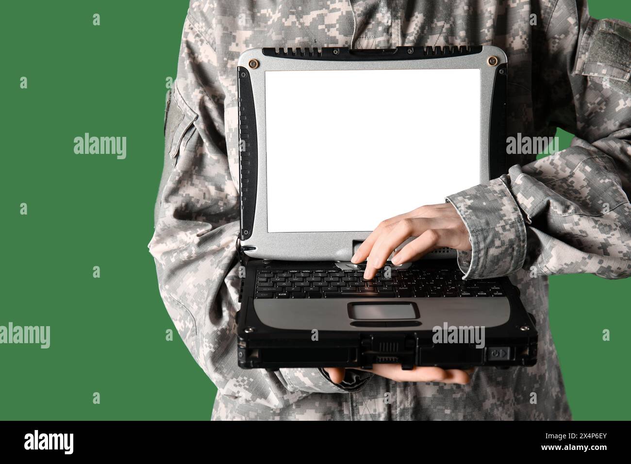 Soldier in uniform holding military laptop with blank screen on green ...