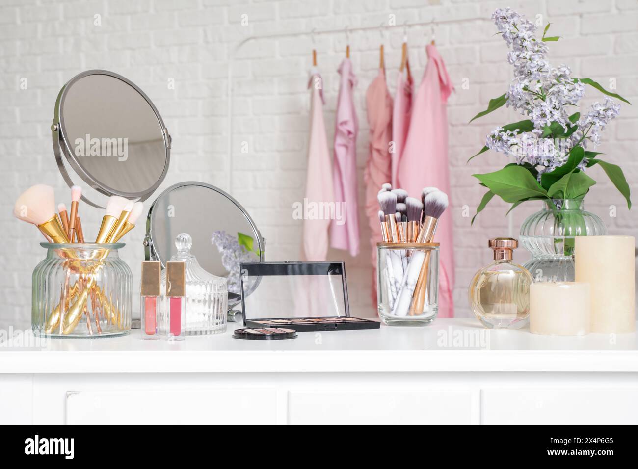 Set of decorative cosmetics, flowers, mirrors and brushes on dressing ...